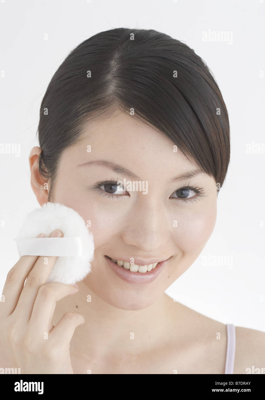 Woman applying powder with puff Stock Photo - Alamy