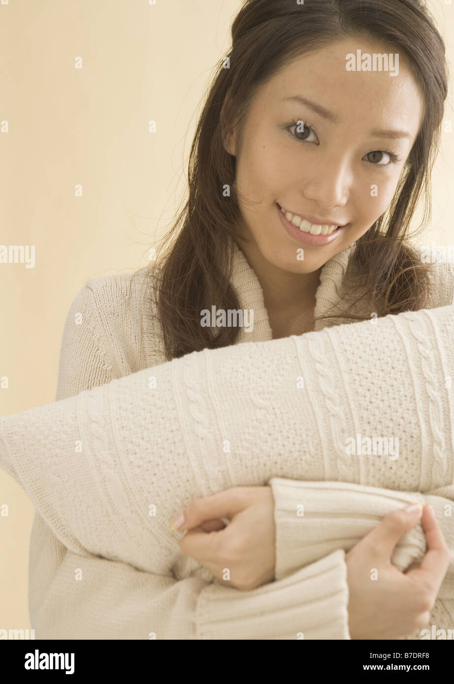 Young woman hugging cushion Stock Photo - Alamy