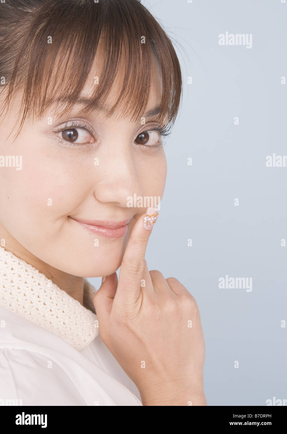 Woman resting finger on face Stock Photo - Alamy