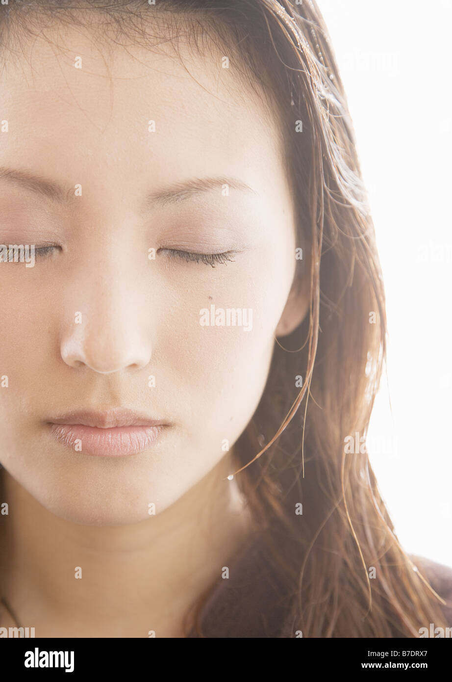Woman with long hair closing eyes Stock Photo - Alamy