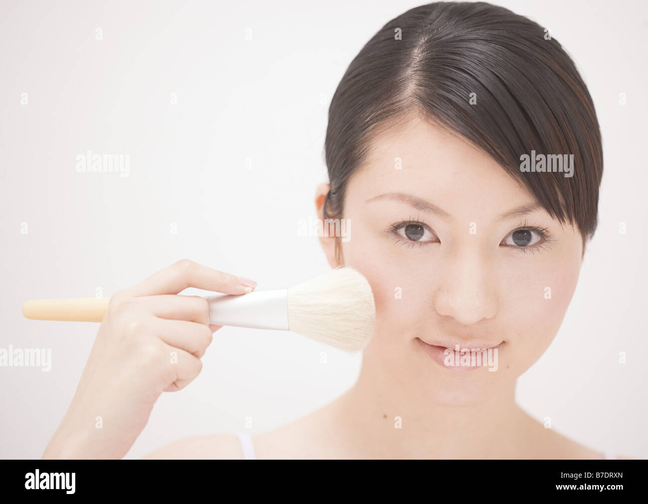 Woman applying blush Stock Photo - Alamy