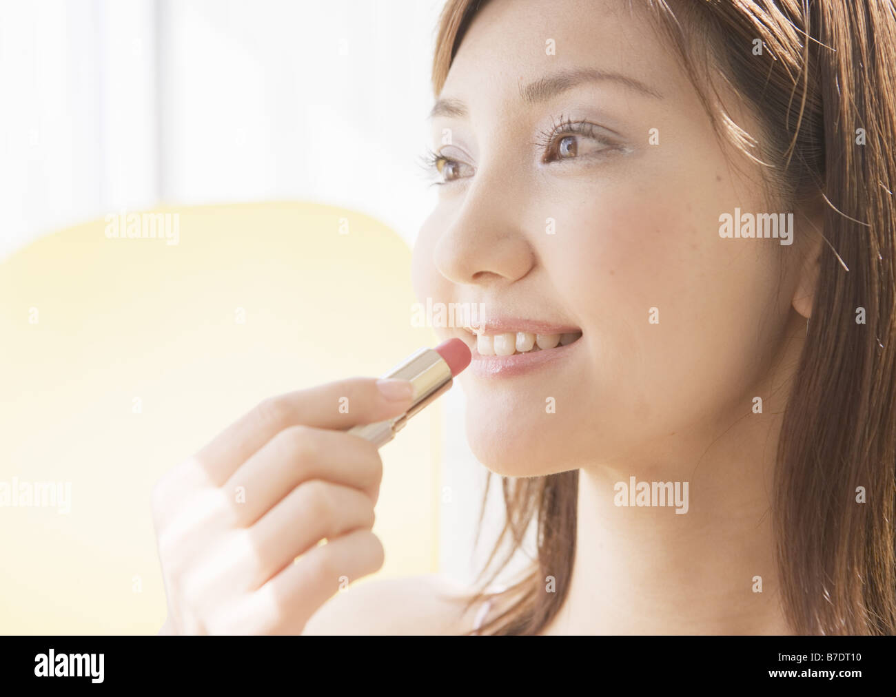 Woman applying lipstick Stock Photo - Alamy