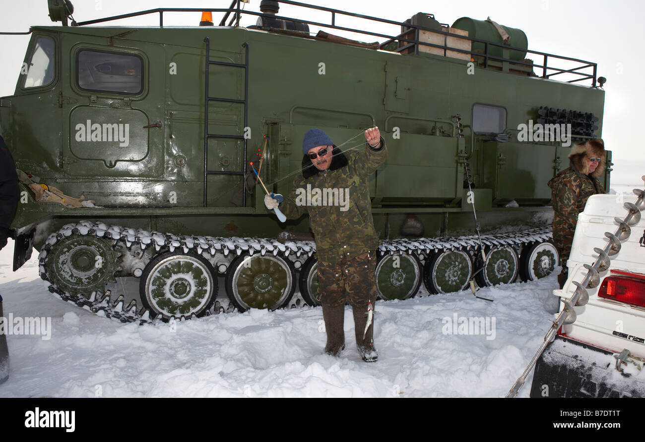 Ice fishing for smelts in front of modified tank (Vezdekhod), Anadyr ...
