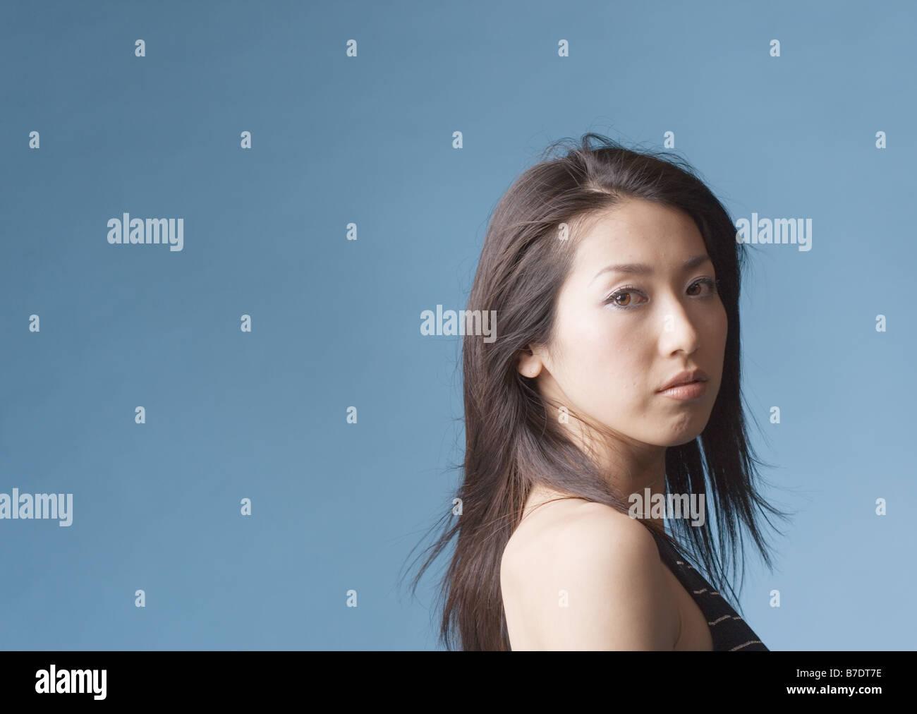 Woman looking over shoulder Stock Photo - Alamy