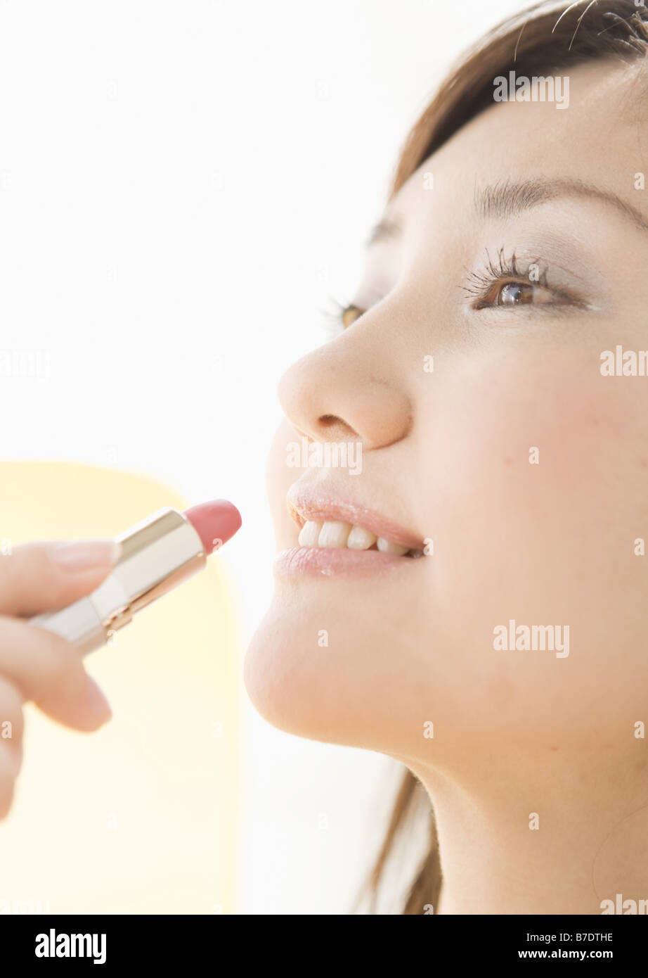 Woman applying lipstick Stock Photo - Alamy