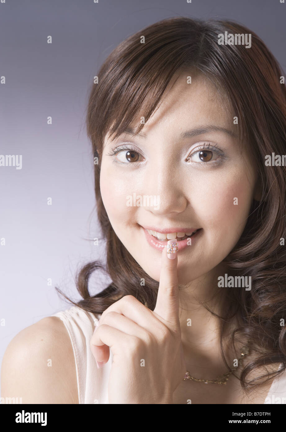 Woman holding finger to lips Stock Photo - Alamy
