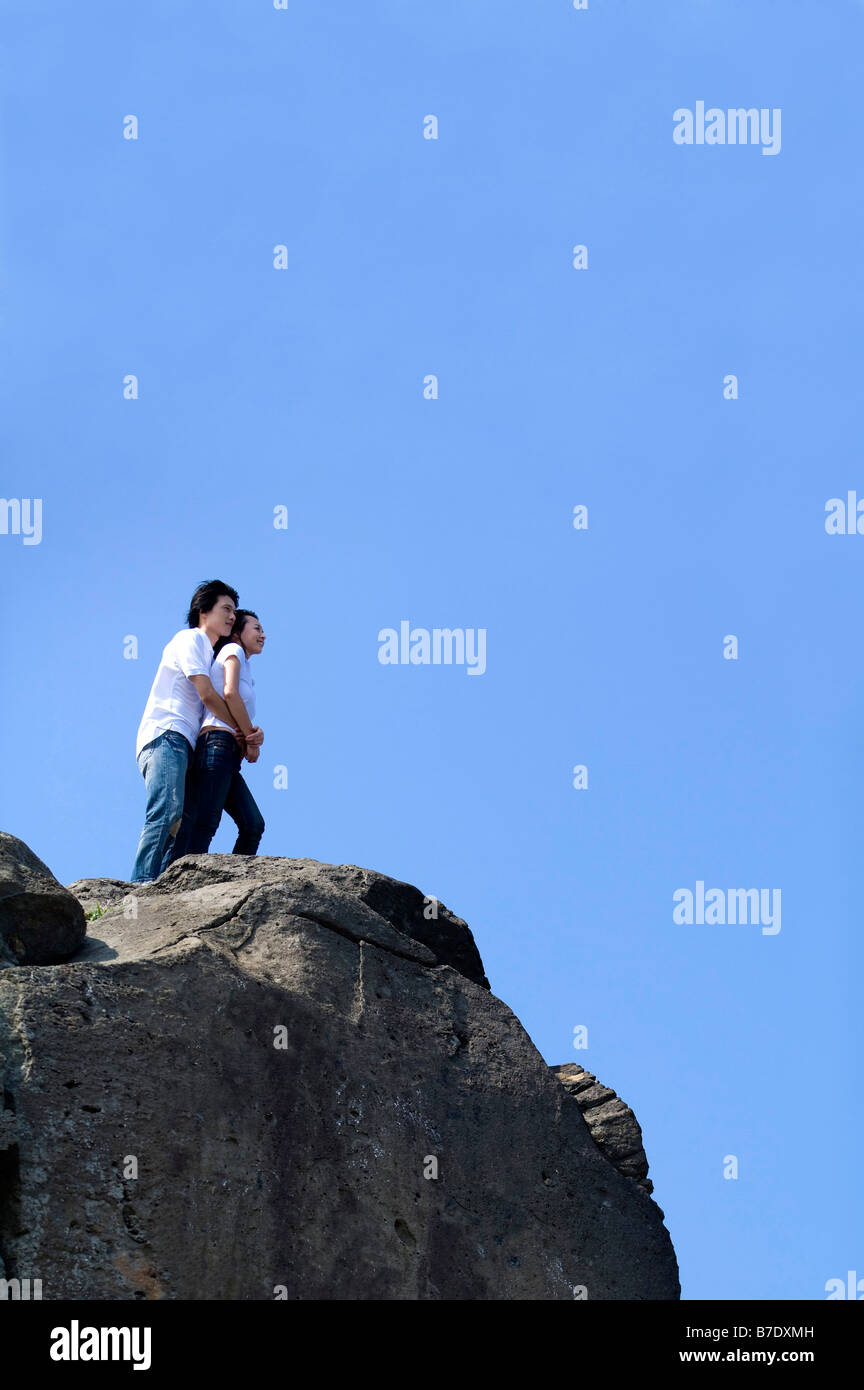 Young couple bonding together on the rock Stock Photo - Alamy