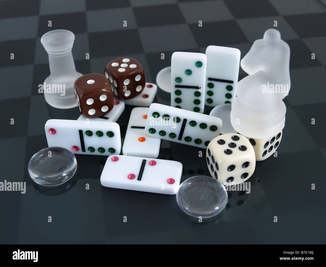 Frosted glass chess pieces dominos dice and stones arranged on a ...