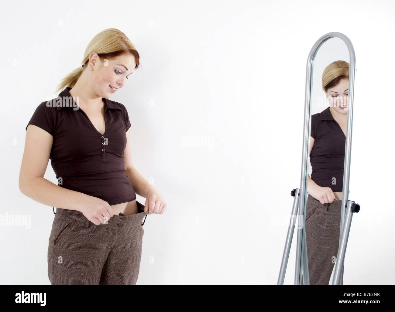 young woman standing in front of a mirror Stock Photo - Alamy