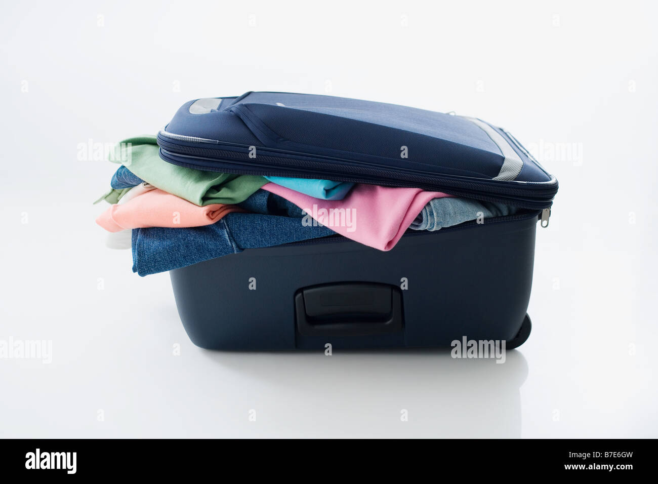 Clothes stuffed in a suitcase Stock Photo - Alamy