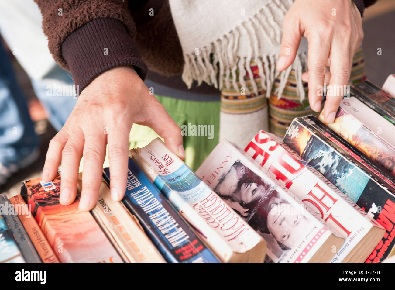 Close Up View Of A Persons Hands Looking Through Used Books On A Second ...