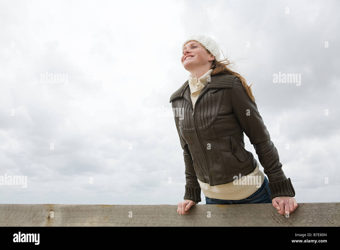 Woman leaning over wall Stock Photo - Alamy