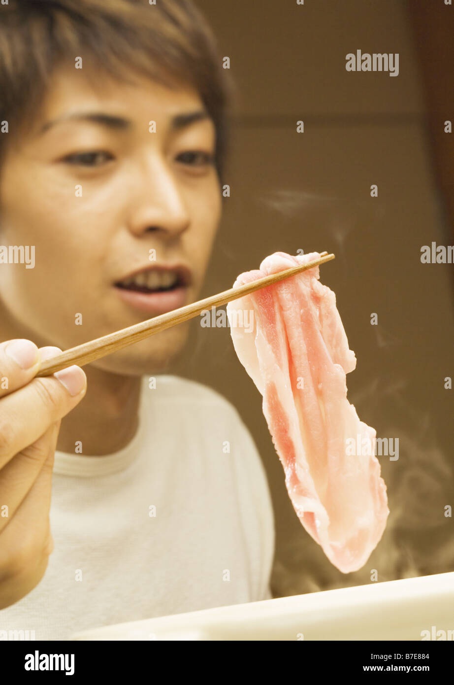 Man Eating Pork One-Pot Stock Photo - Alamy