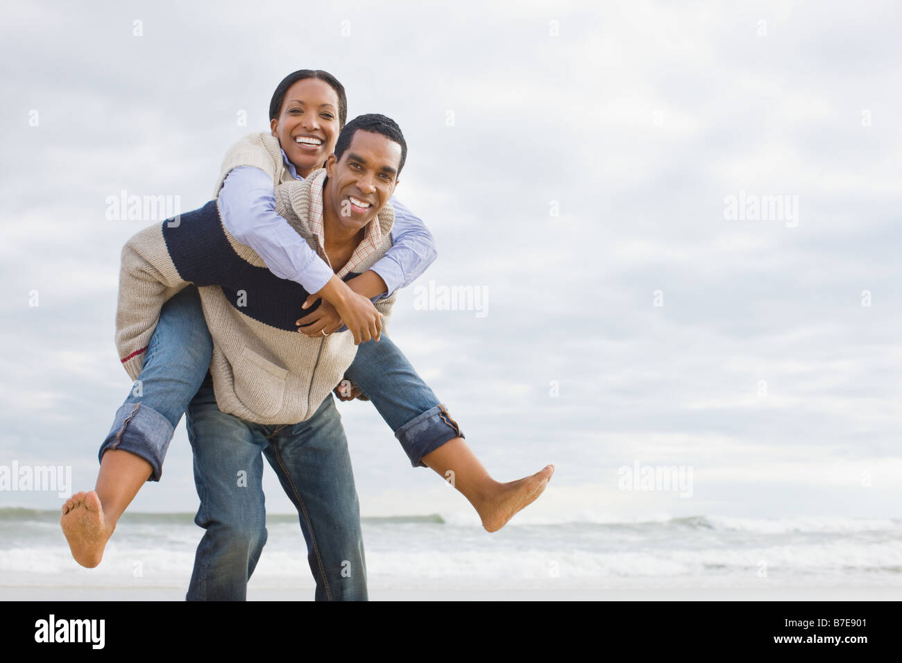 Man giving woman piggyback by the sea Stock Photo - Alamy