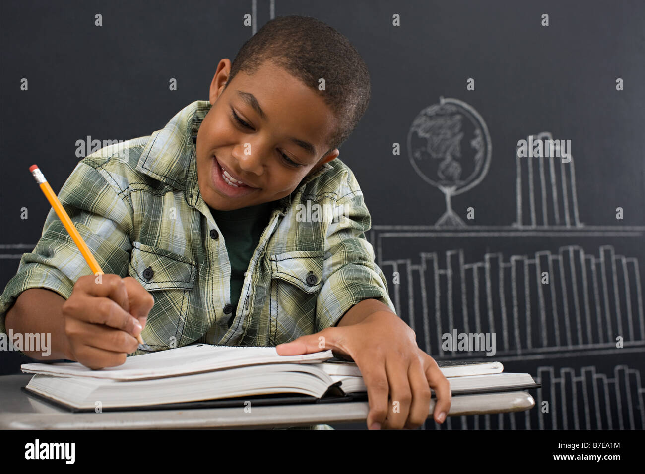 A boy writing in a notebook Stock Photo - Alamy