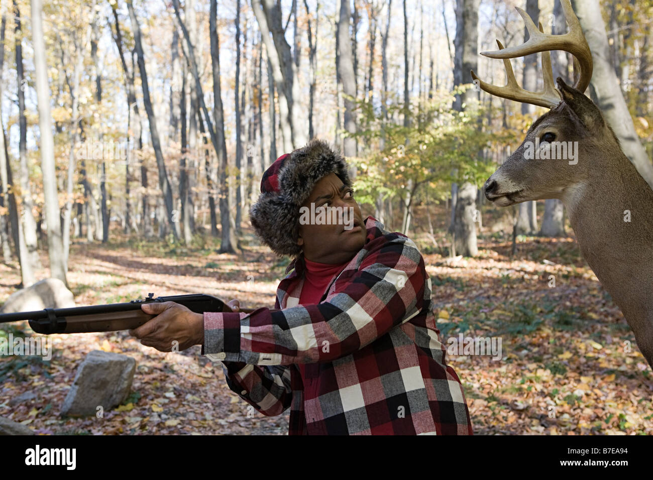 Deer standing behind a hunter Stock Photo - Alamy