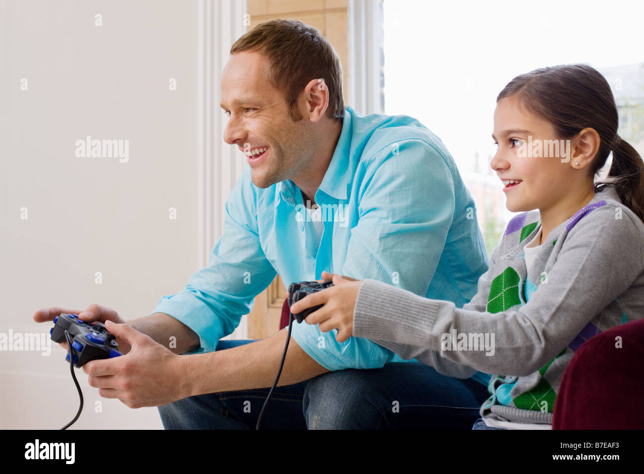 Father and daughter playing video game Stock Photo - Alamy