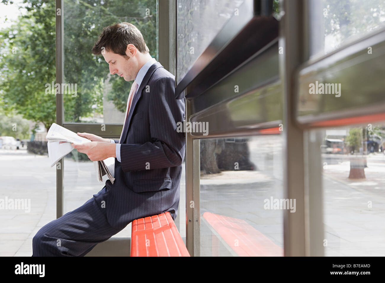 Reading newspaper bus stop hi-res stock photography and images - Alamy