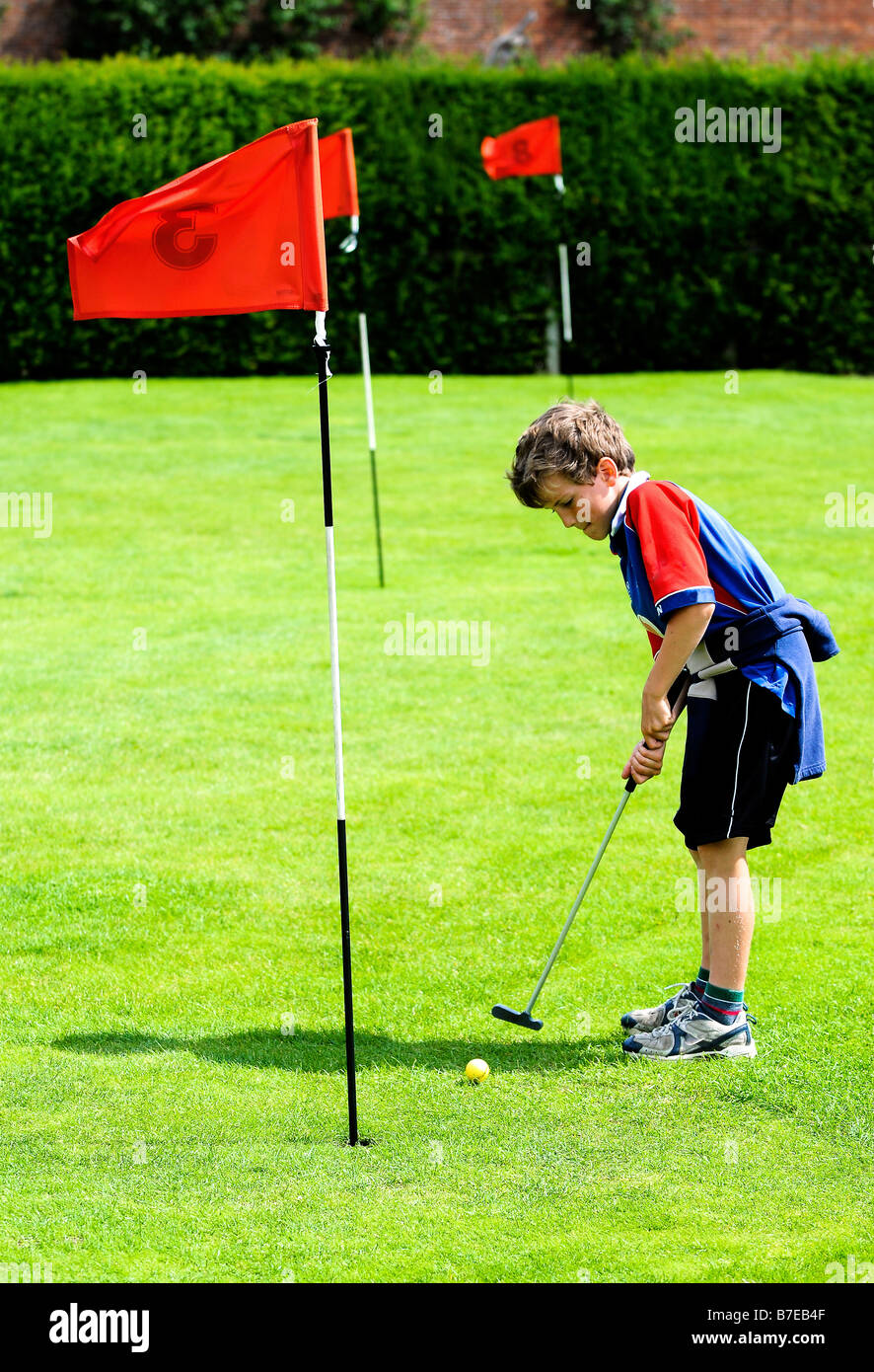 outdoor portrait of boy playing mini golf Stock Photo - Alamy