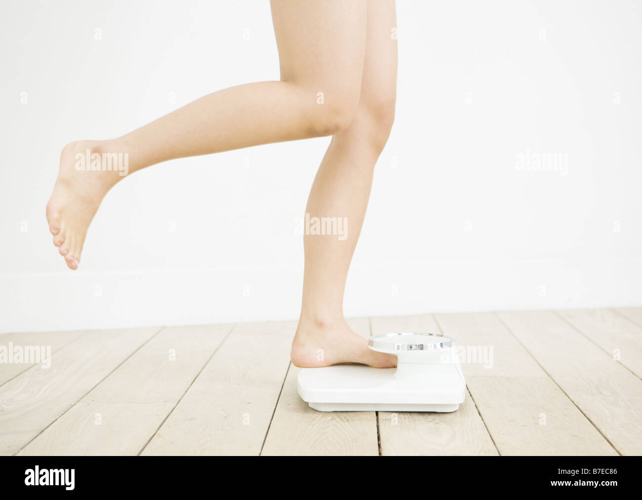 Woman getting on the scale Stock Photo - Alamy