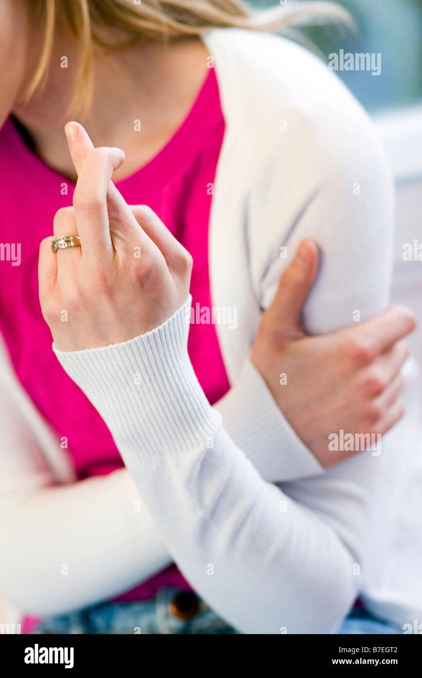 Woman with fingers crossed Stock Photo - Alamy