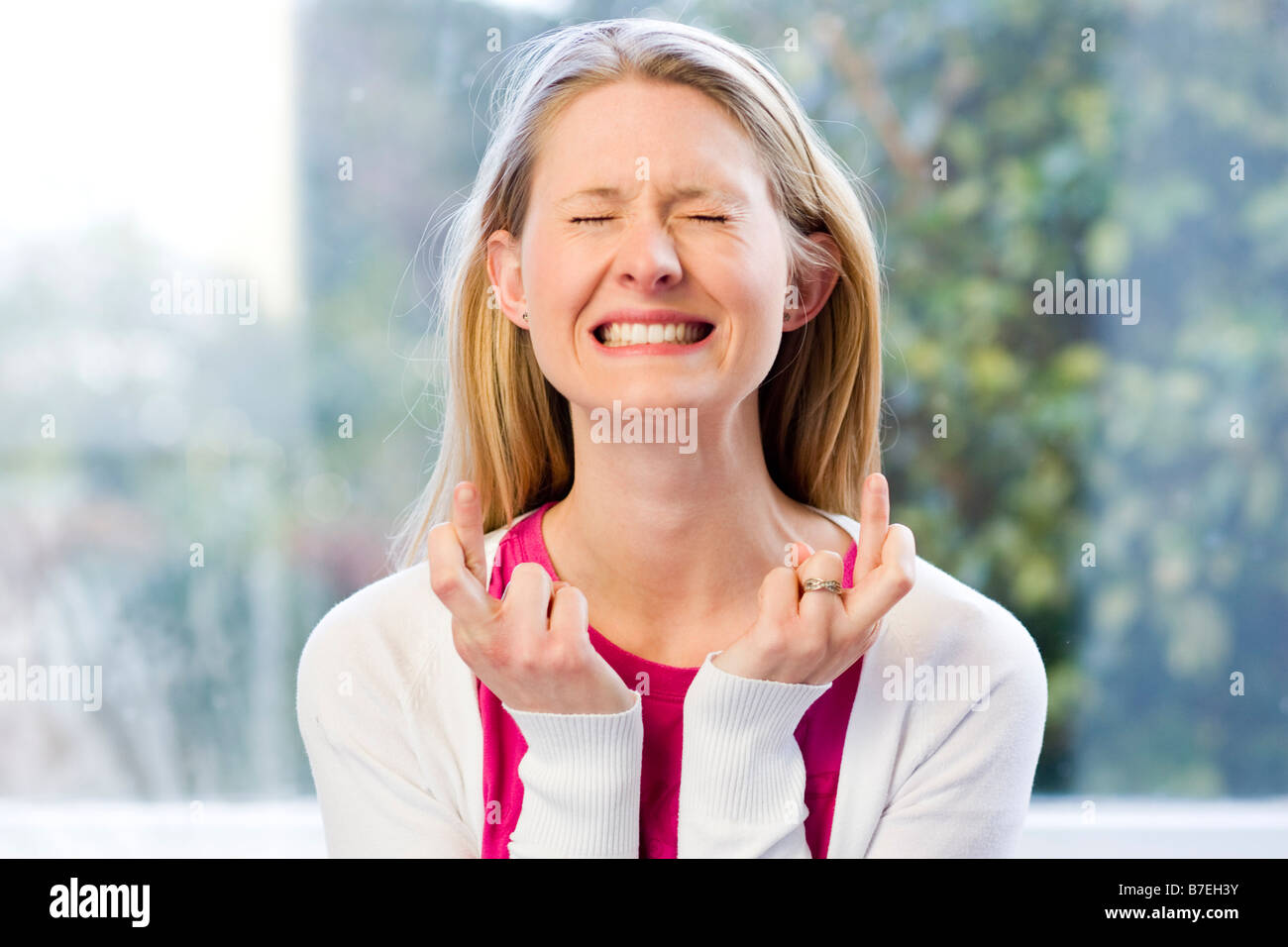Woman with fingers crossed Stock Photo - Alamy