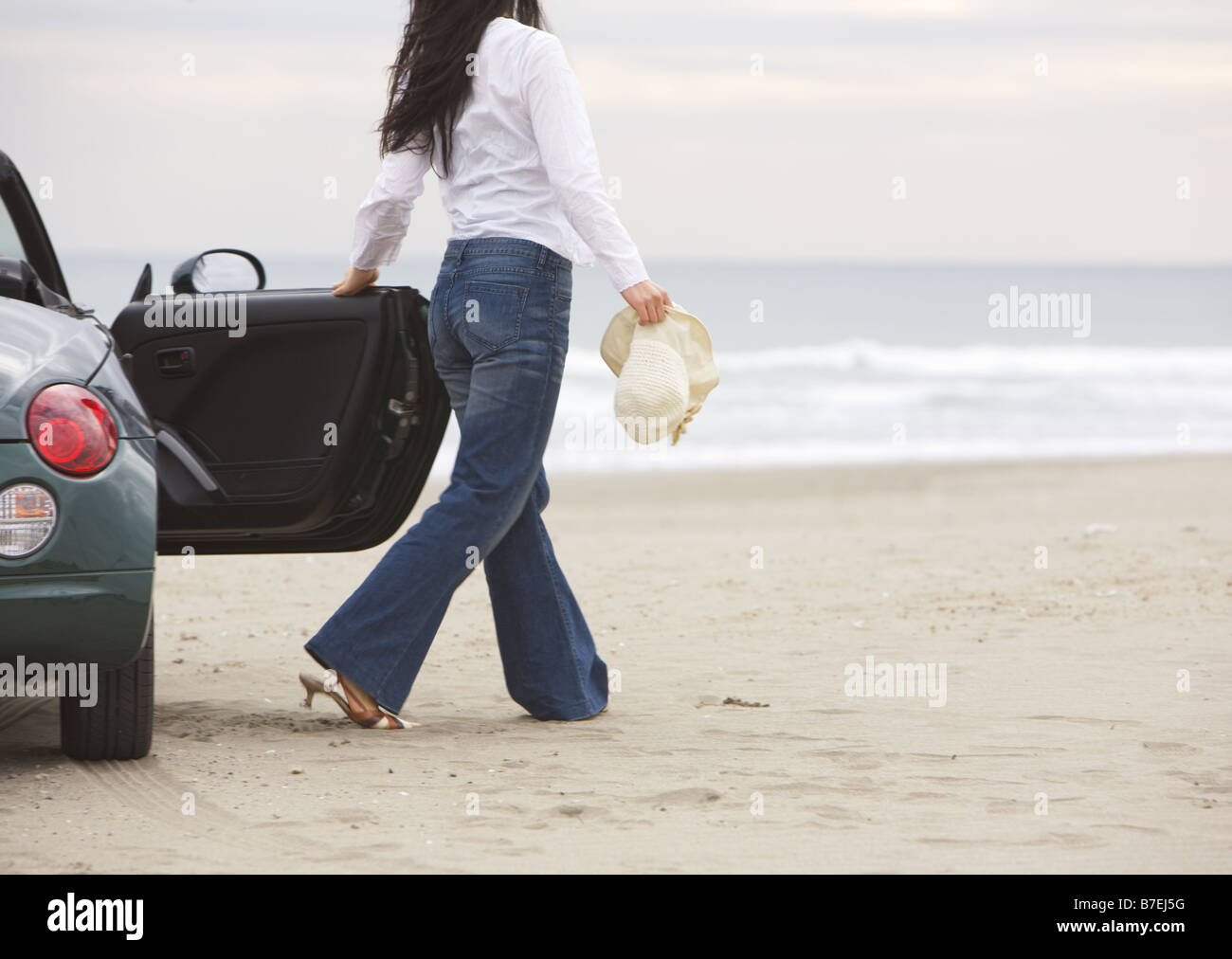 A woman taking a walk on a sandy beach Stock Photo - Alamy