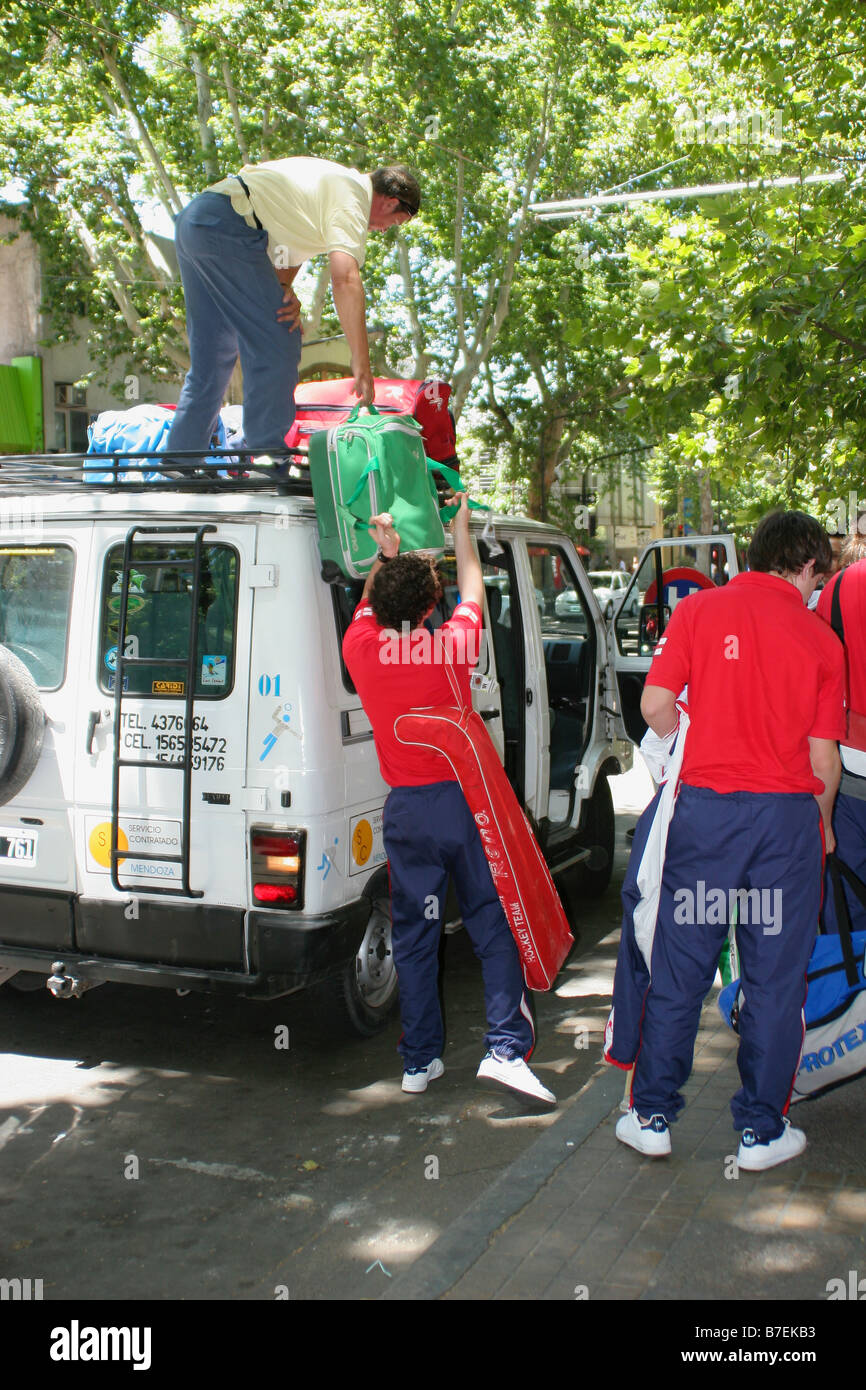Sports people loading the top of a minibus with kit bags Stock Photo ...
