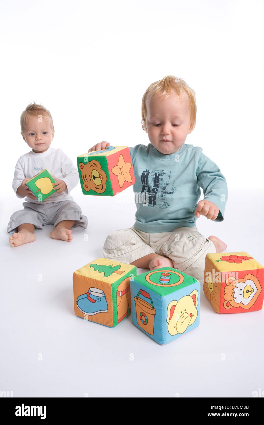 Two toddlers playing with soft bricks Stock Photo - Alamy