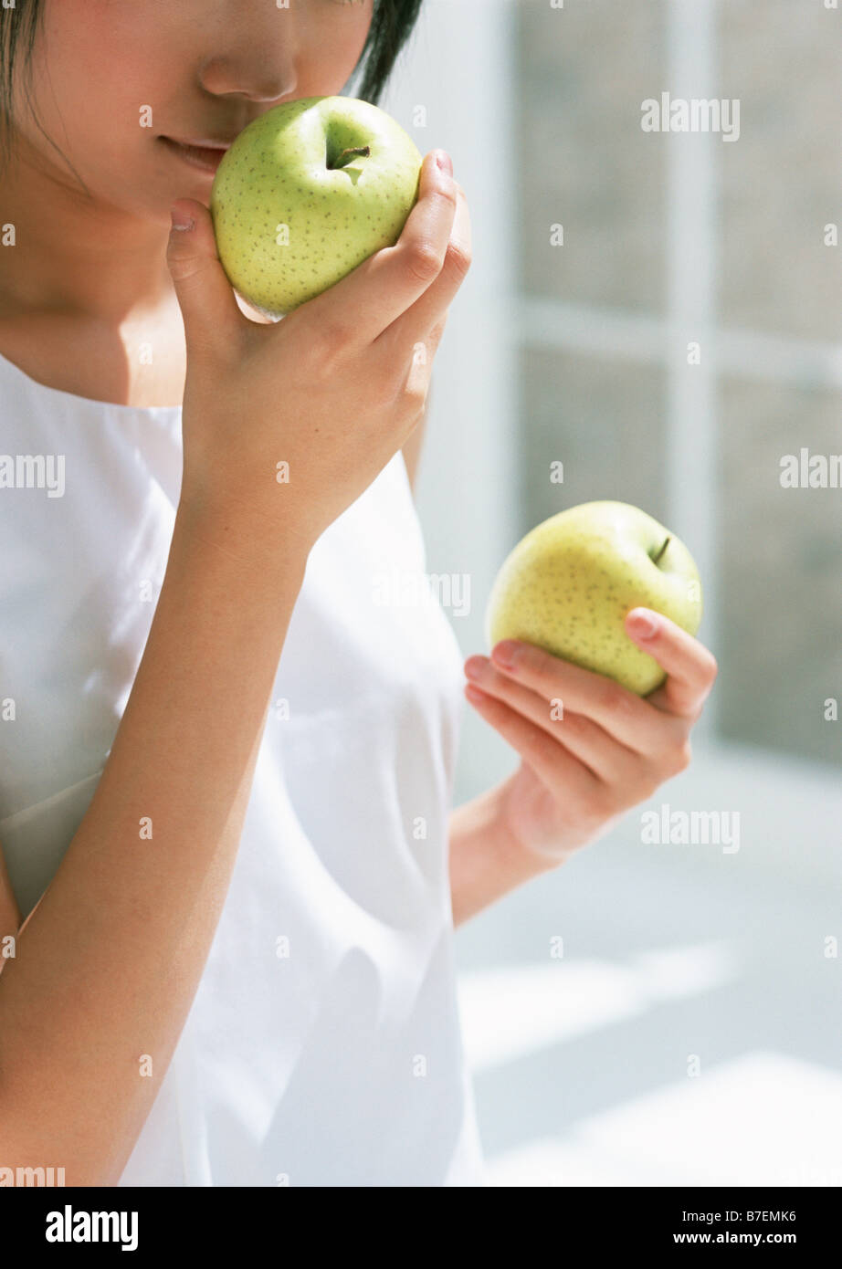 Woman smelling at green apple Stock Photo - Alamy