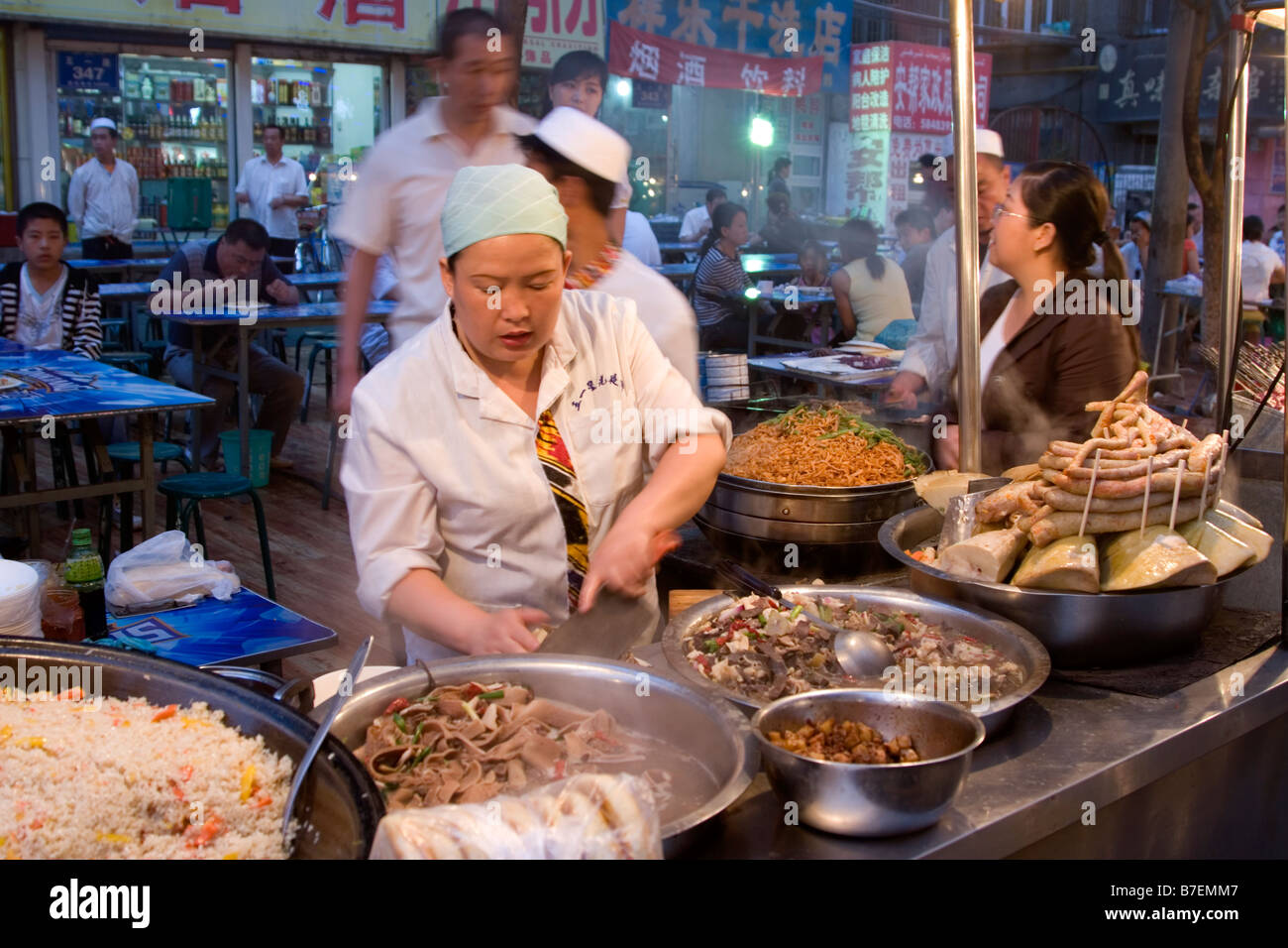 Chinese cooking in the night market in Urumqi in Xinjiang in China ...