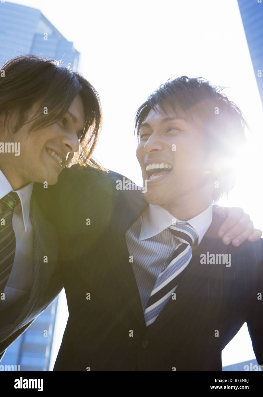 Businessmen with arms around shoulder Stock Photo - Alamy