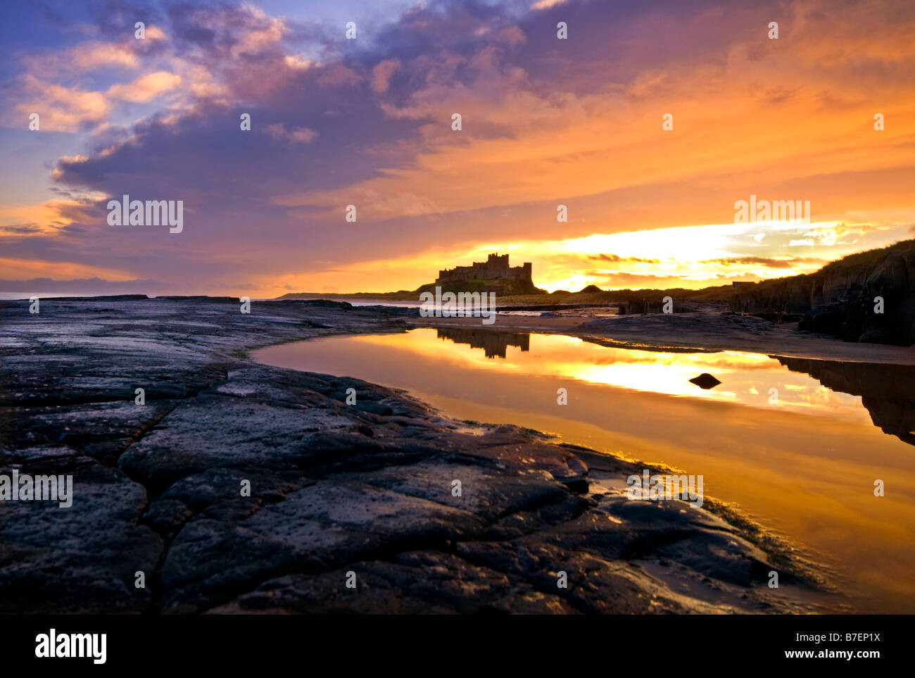 Sunrise over the beach and castle at Bamburgh on the Northumberland ...