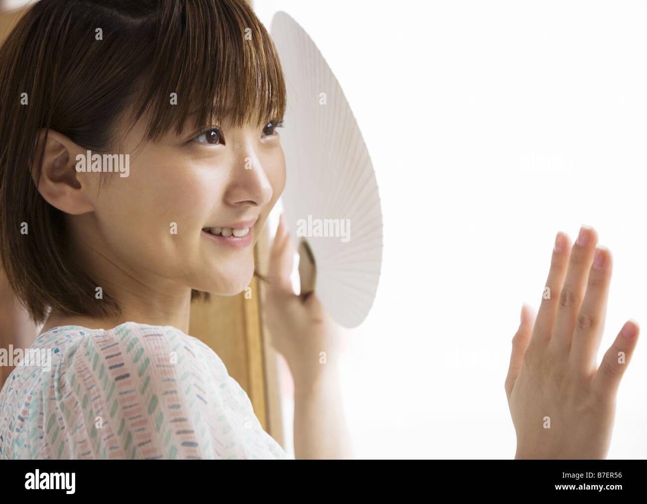A woman holding a paper fan Stock Photo - Alamy