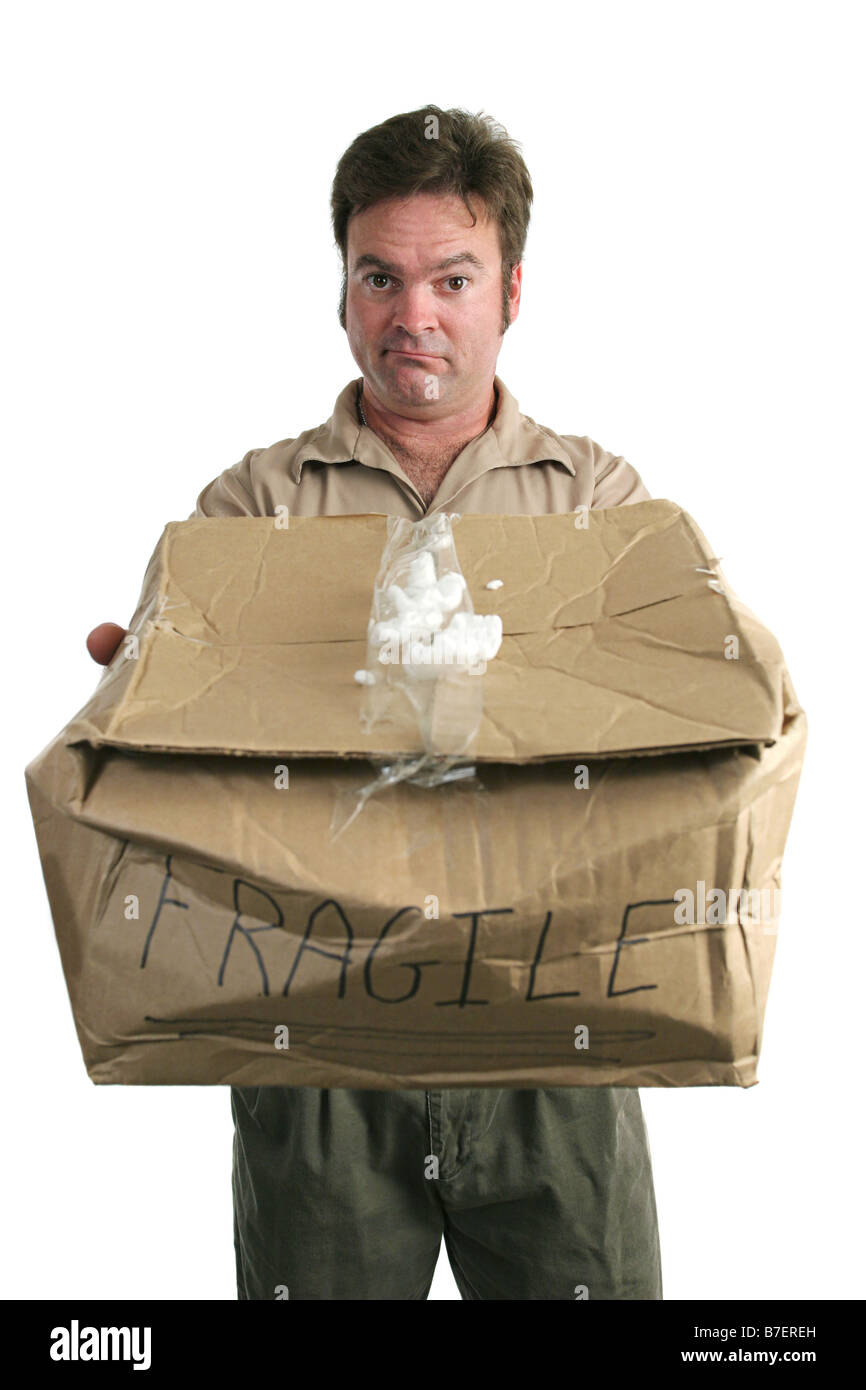 A delivery man holding a smashed package and looking guilty Stock Photo ...