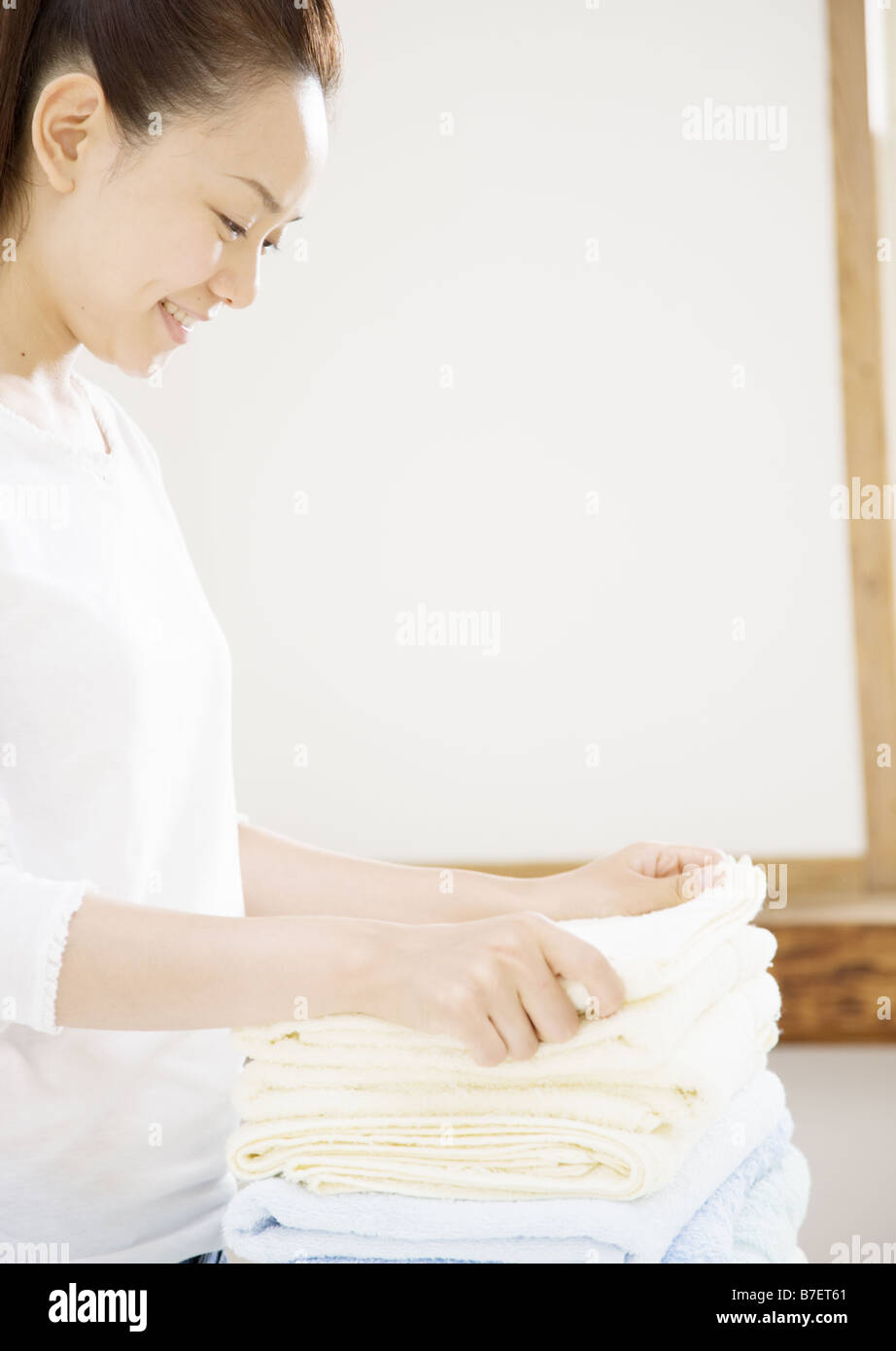 A woman folding towel Stock Photo - Alamy