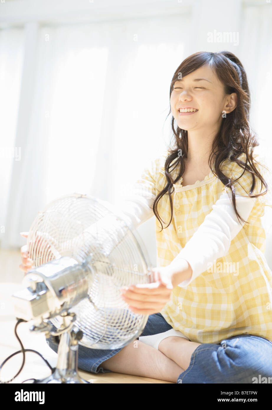 Woman sitting in front of an electric fan hi-res stock photography and ...