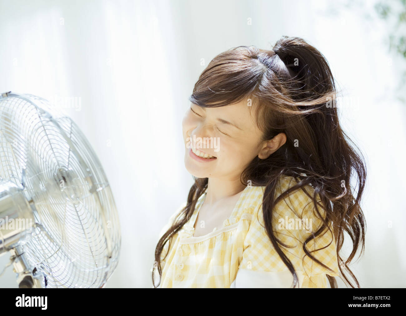 A woman in front of fan Stock Photo - Alamy