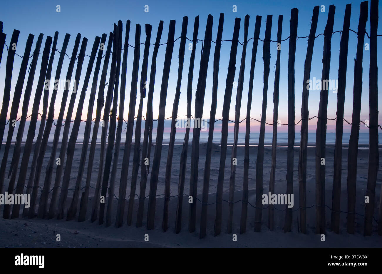 wooden fence on the beach with sunset background Stock Photo - Alamy