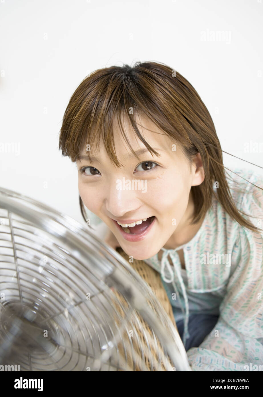 A woman in front of fan Stock Photo - Alamy