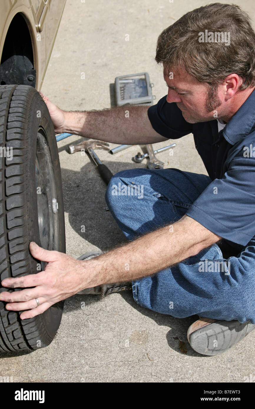 An auto mechanic removing a car tire Stock Photo - Alamy