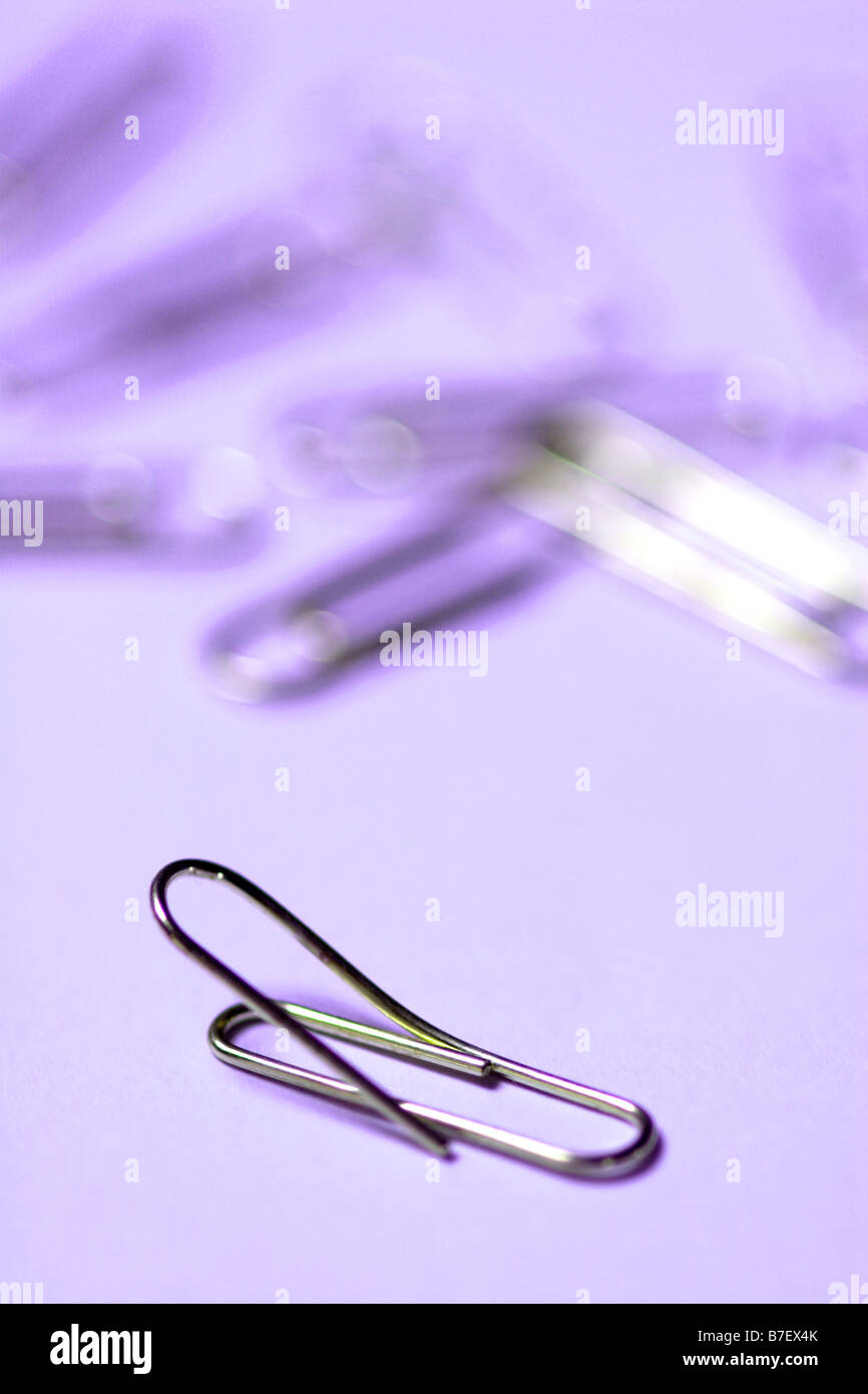 Bent paperclip on paper close up Stock Photo - Alamy