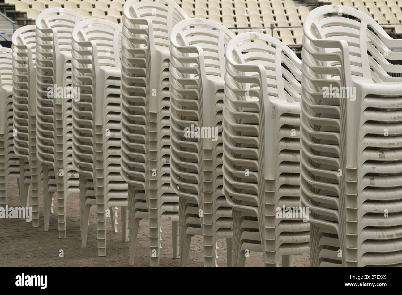 row of white plastic stacking chairs Stock Photo - Alamy