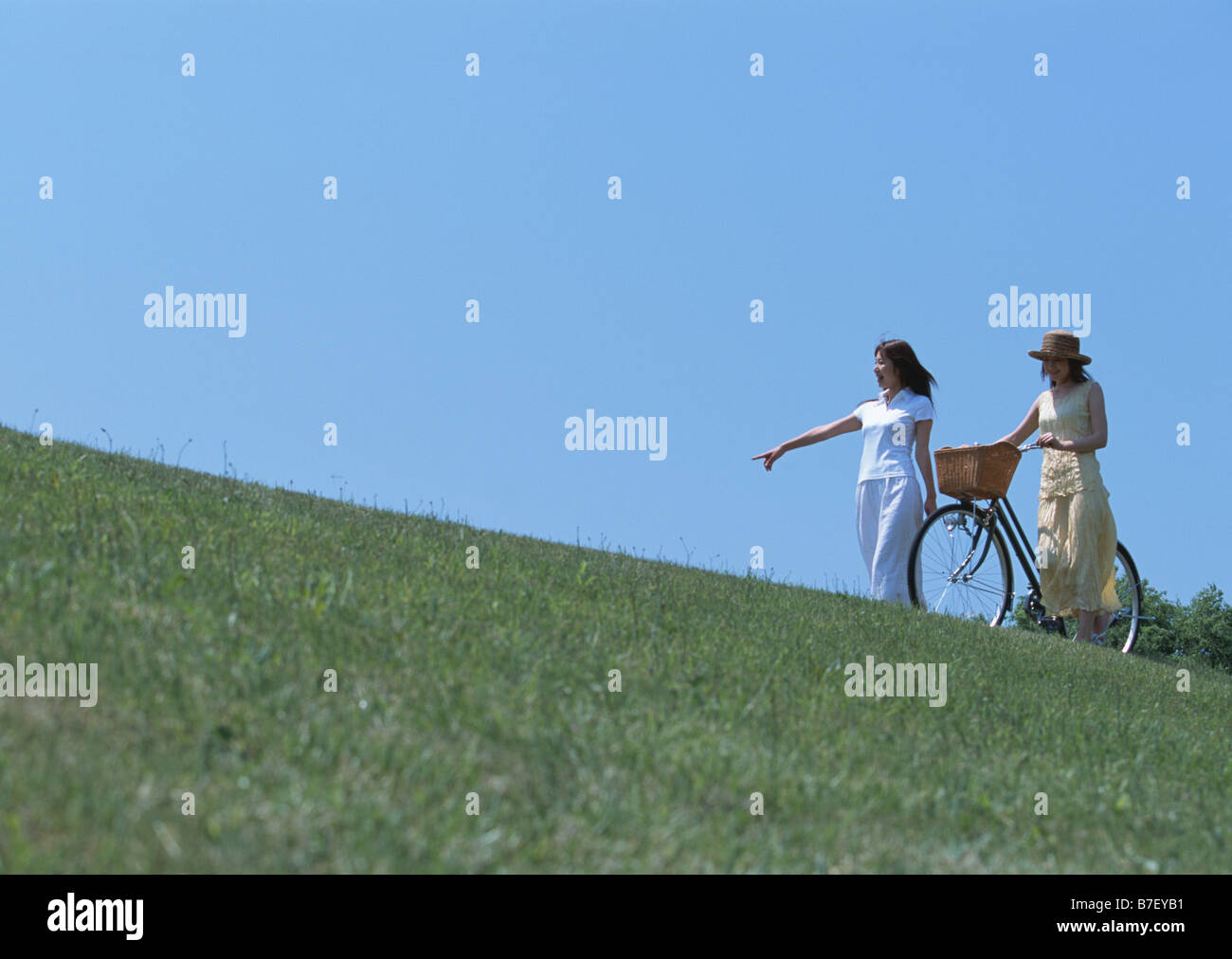 Women walking with bicycle Stock Photo - Alamy