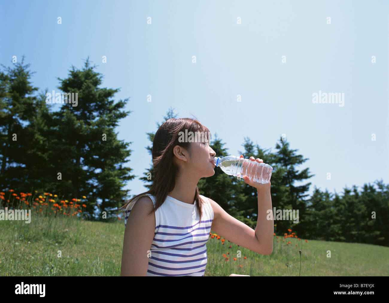 Woman drinking water in field Stock Photo - Alamy