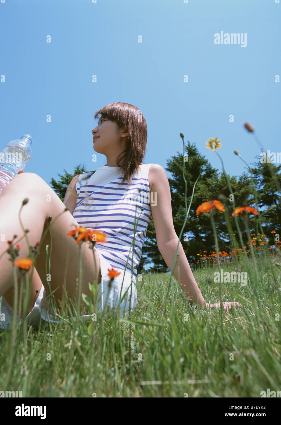 Woman sitting in field Stock Photo - Alamy