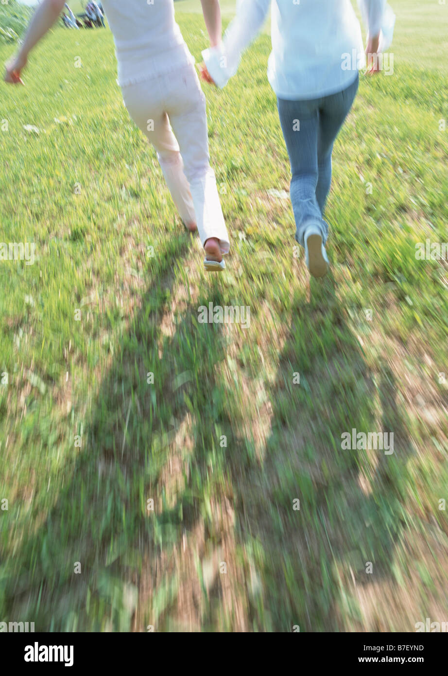 Women running hand in hand Stock Photo - Alamy