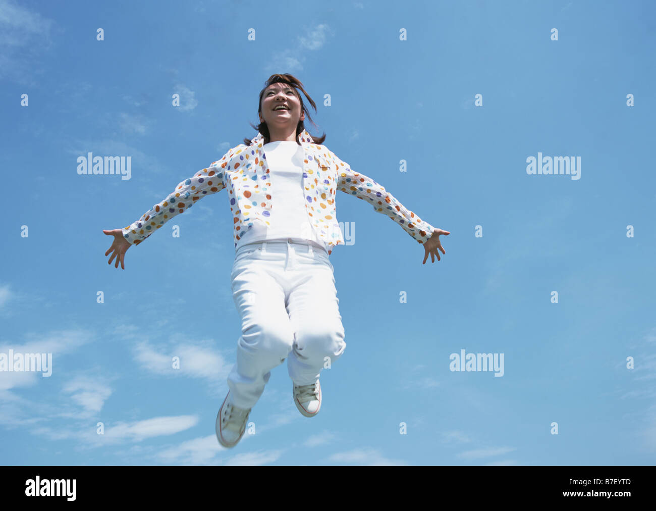 Young woman jumping up in field Stock Photo - Alamy