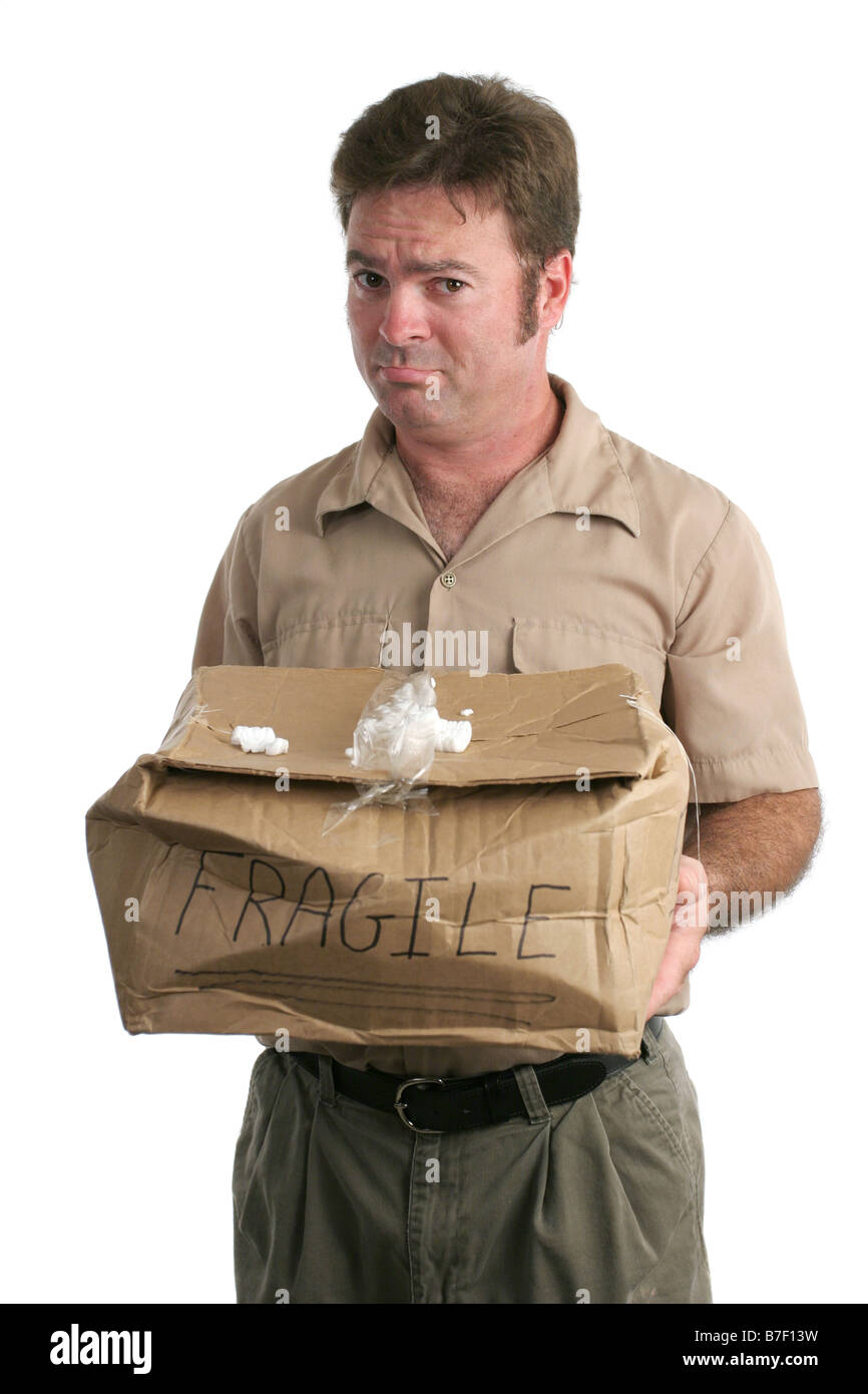 A delivery man holding out a smashed package and looking very sorry ...