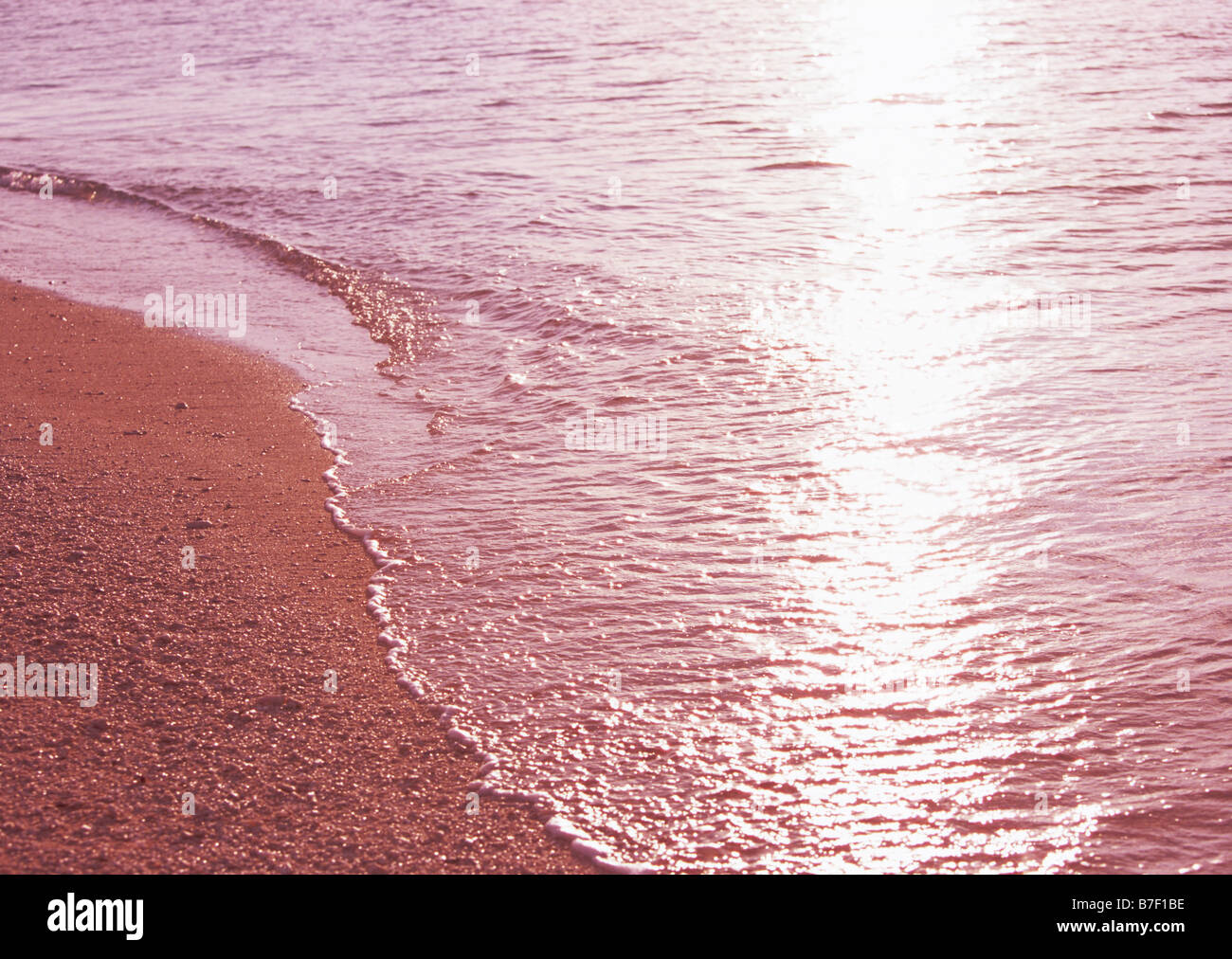 Wave lapping onto shore before sunset Stock Photo - Alamy